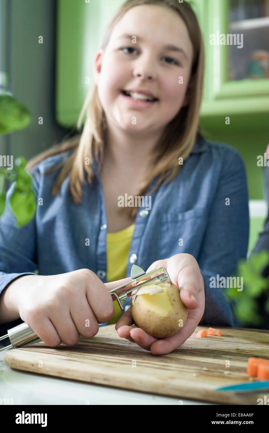 Girl in kitchen peeling vegetabels Stock Photo - Alamy