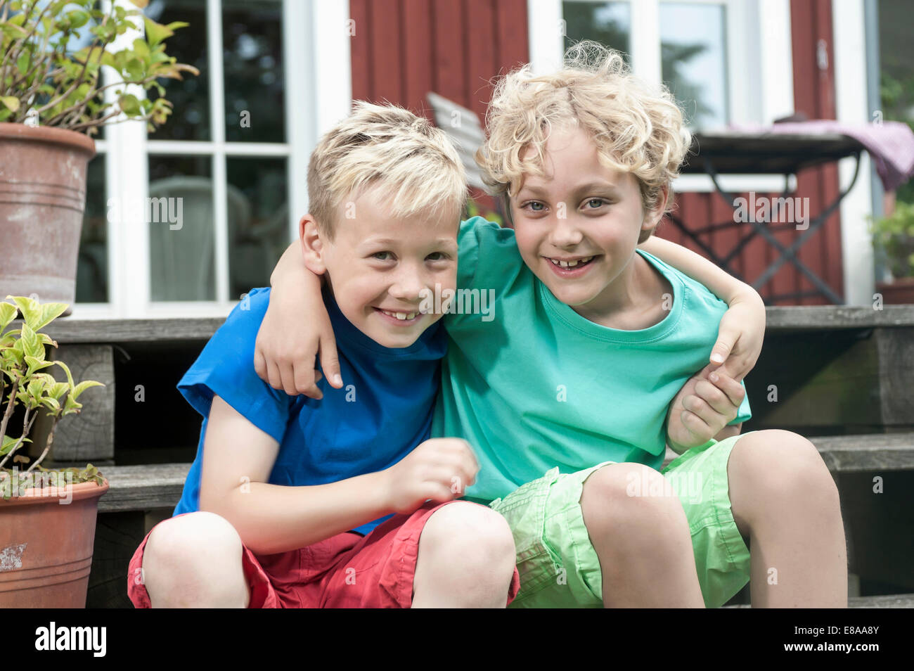 Friends young boys sitting steps house smiling Stock Photo - Alamy