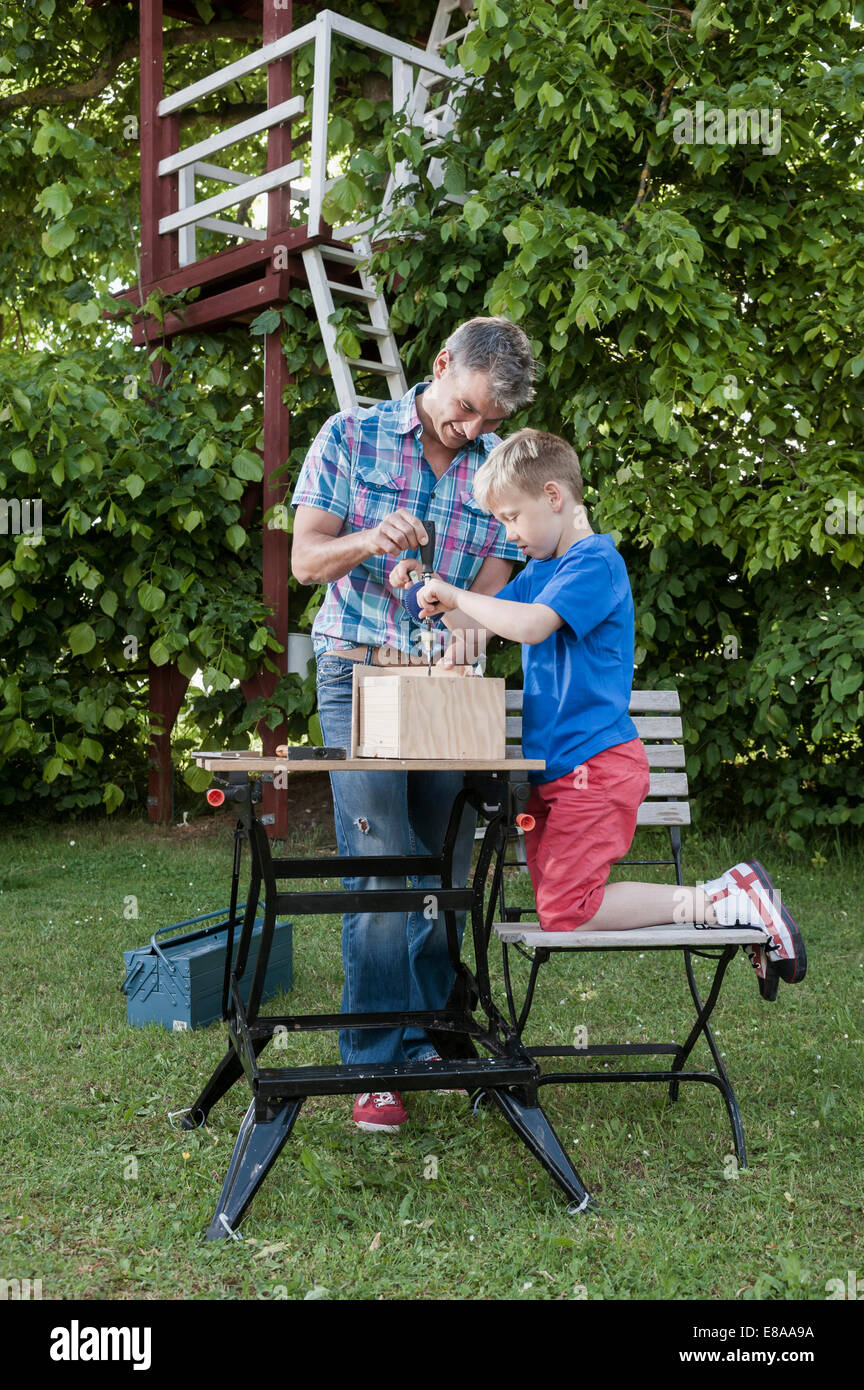 Building birdhouse father son together working Stock Photo - Alamy