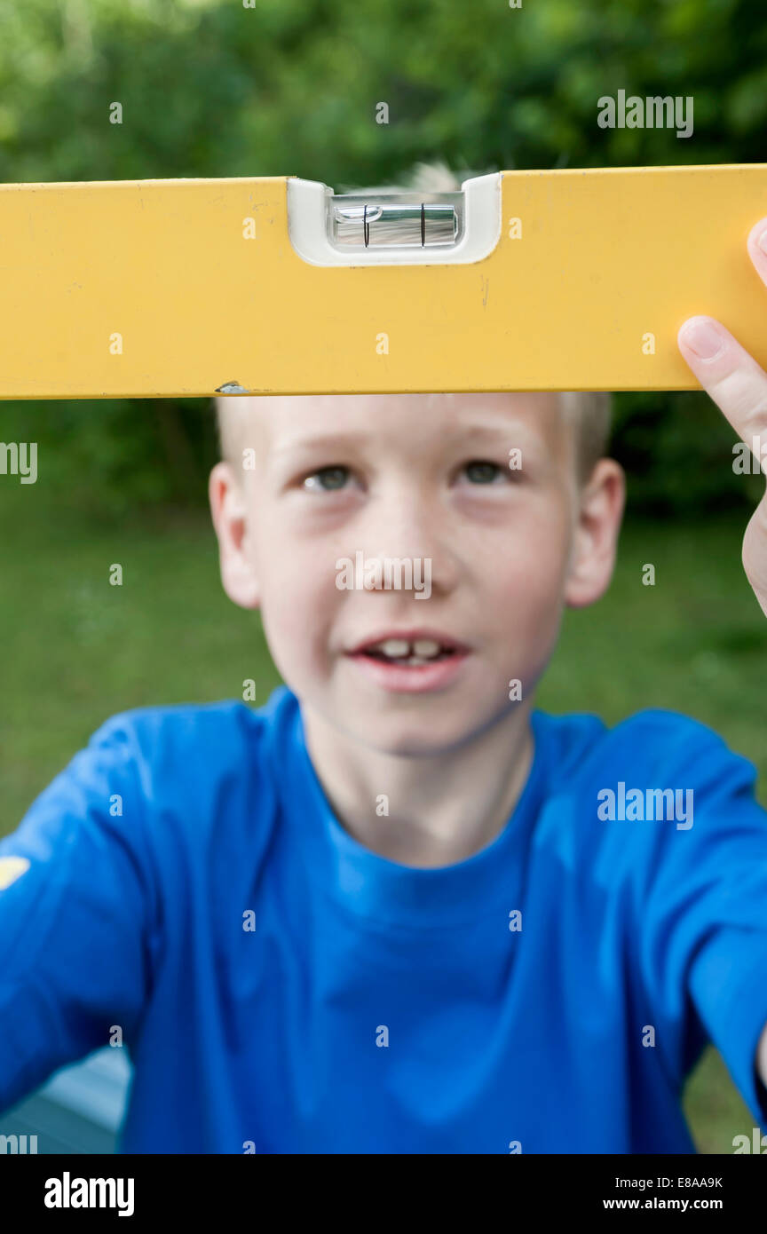 Portrait young blond boy holding spirit level Stock Photo - Alamy