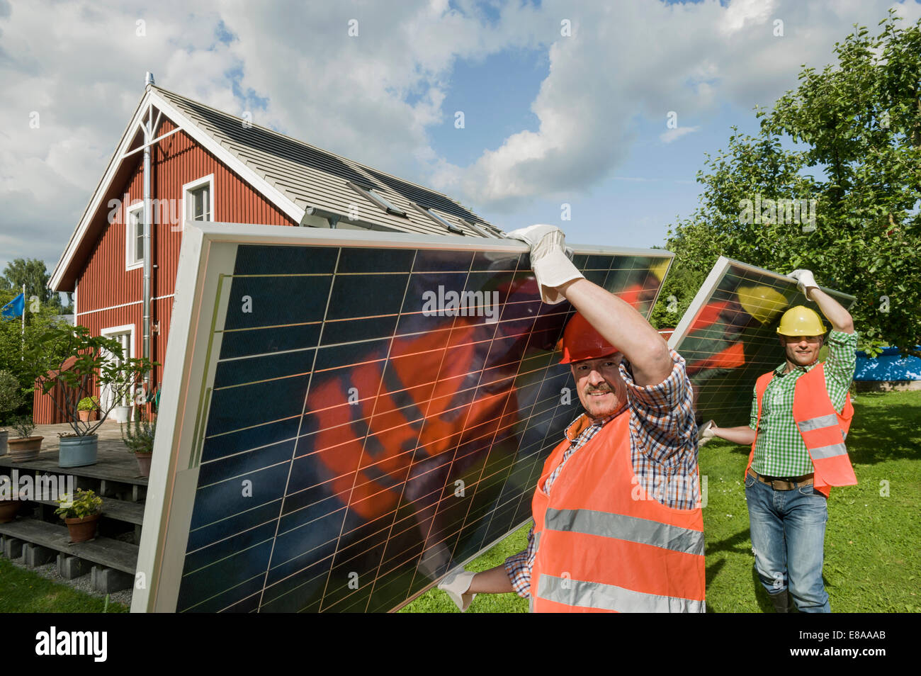 Workmen delivering solar panel house garden Stock Photo - Alamy