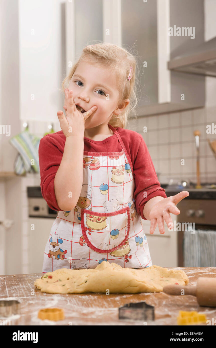 Girl nibbling dough, portrait Stock Photo - Alamy