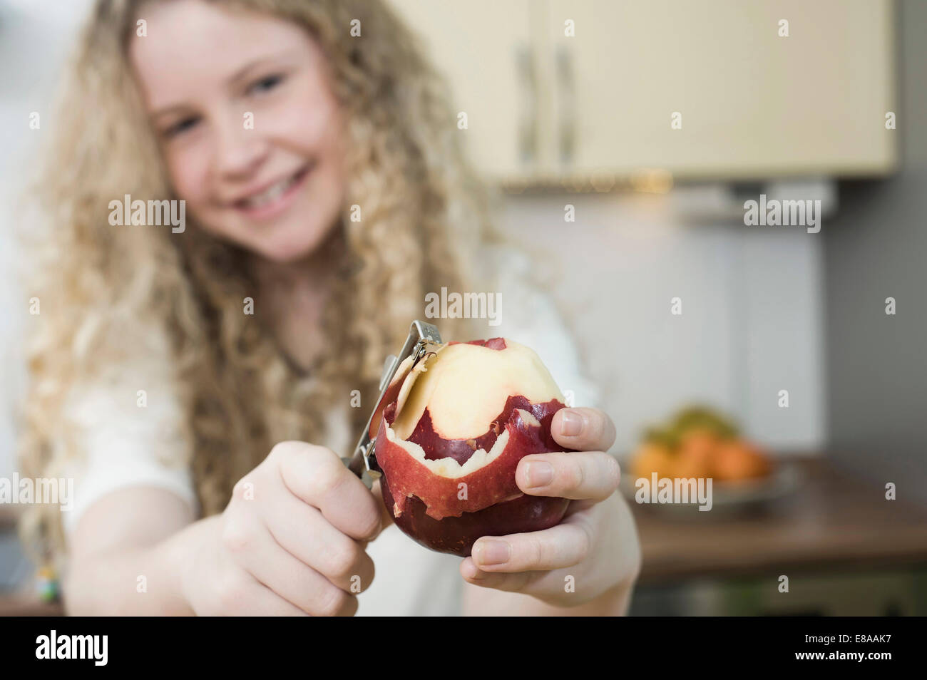 Girl in kitchen peeling apple Stock Photo - Alamy