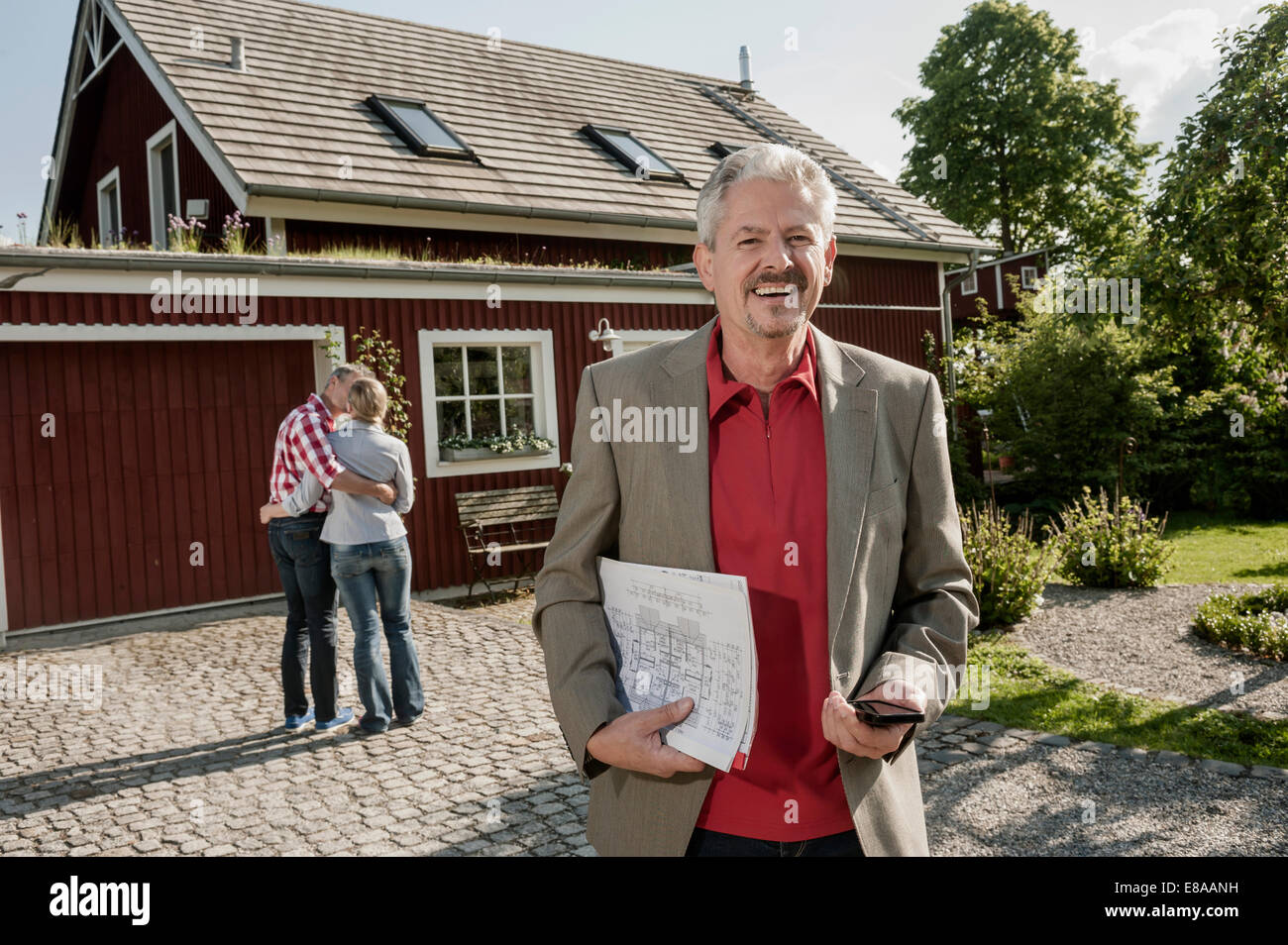 Couple viewing new home estate agent smiling Stock Photo - Alamy
