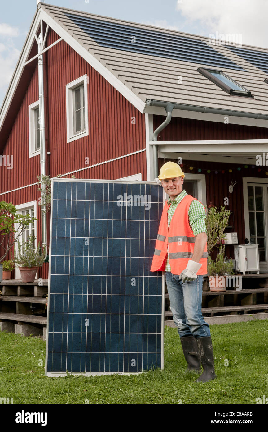 Timber house workman solar panel portrait Stock Photo - Alamy
