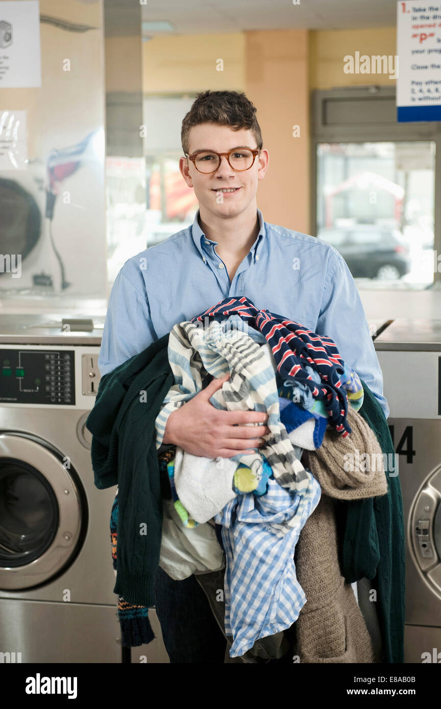 Portrait of young man with laundry, smiling Stock Photo - Alamy
