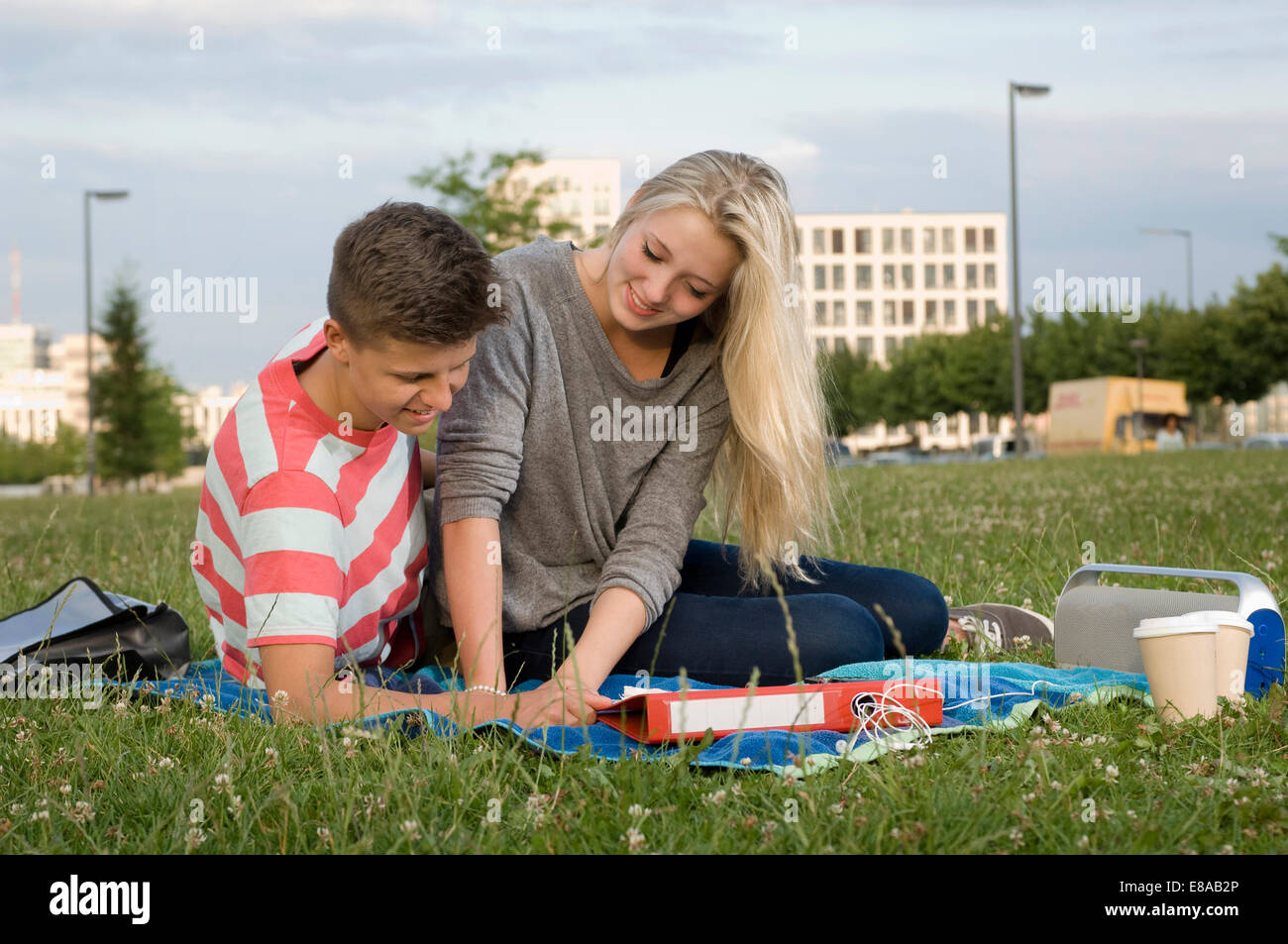 Teenage couple doing homework in park, smiling Stock Photo - Alamy