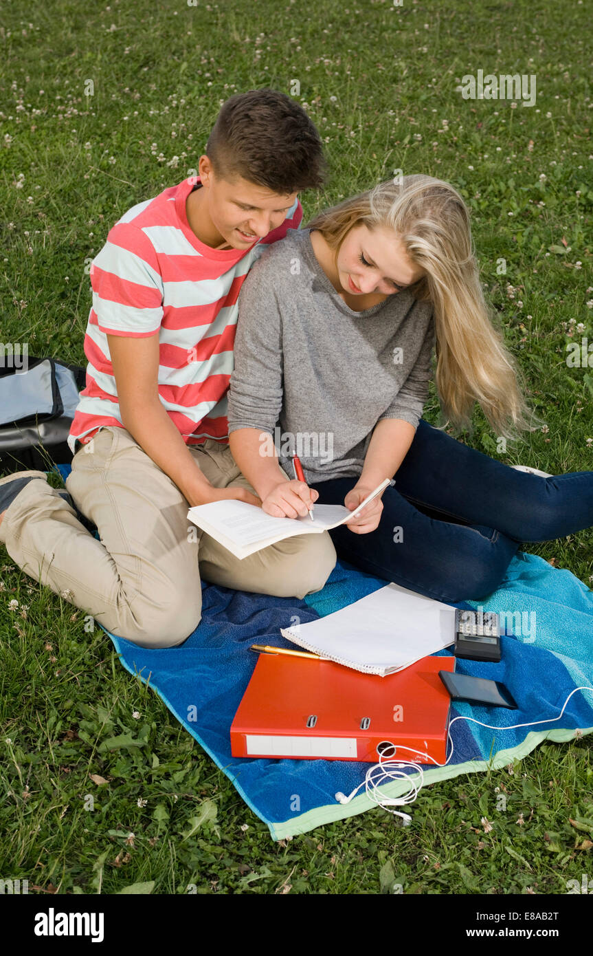 Teenage couple doing homework in park Stock Photo - Alamy