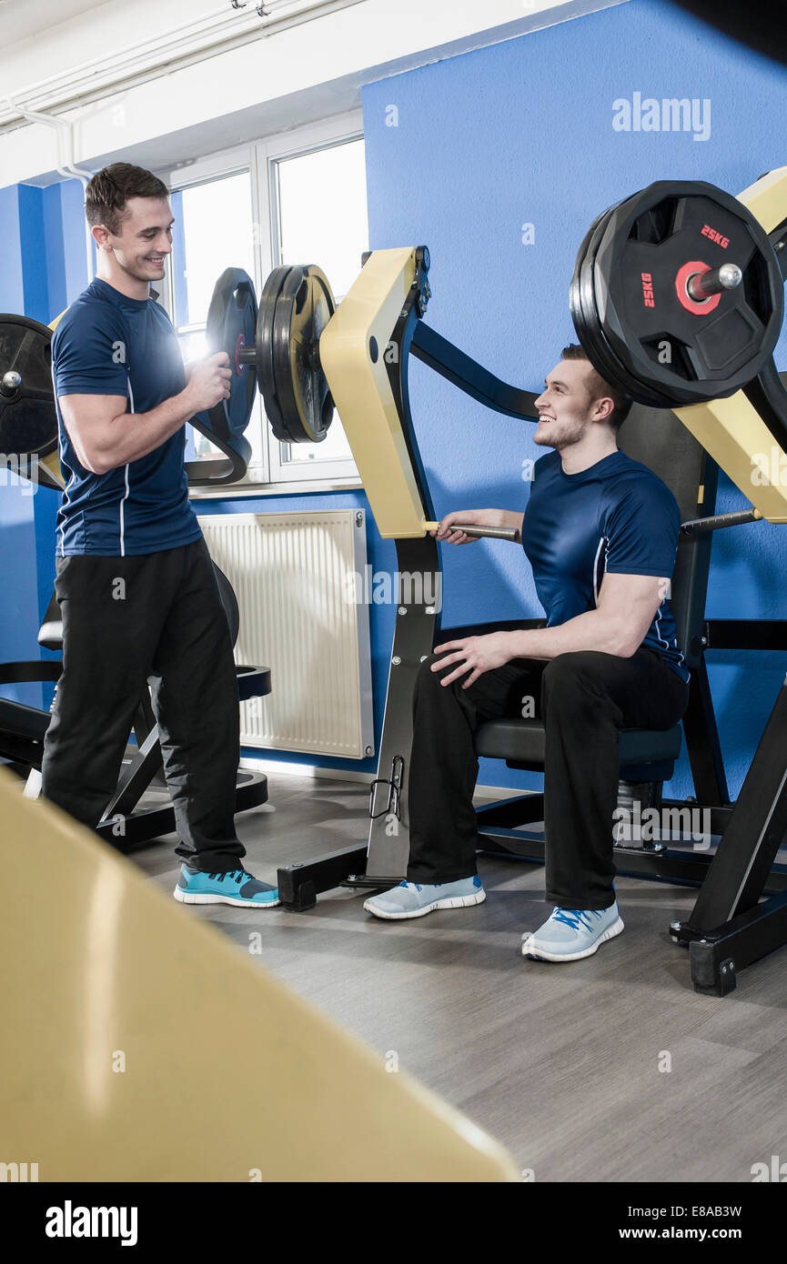 Two young men in gym doing weight training Stock Photo - Alamy