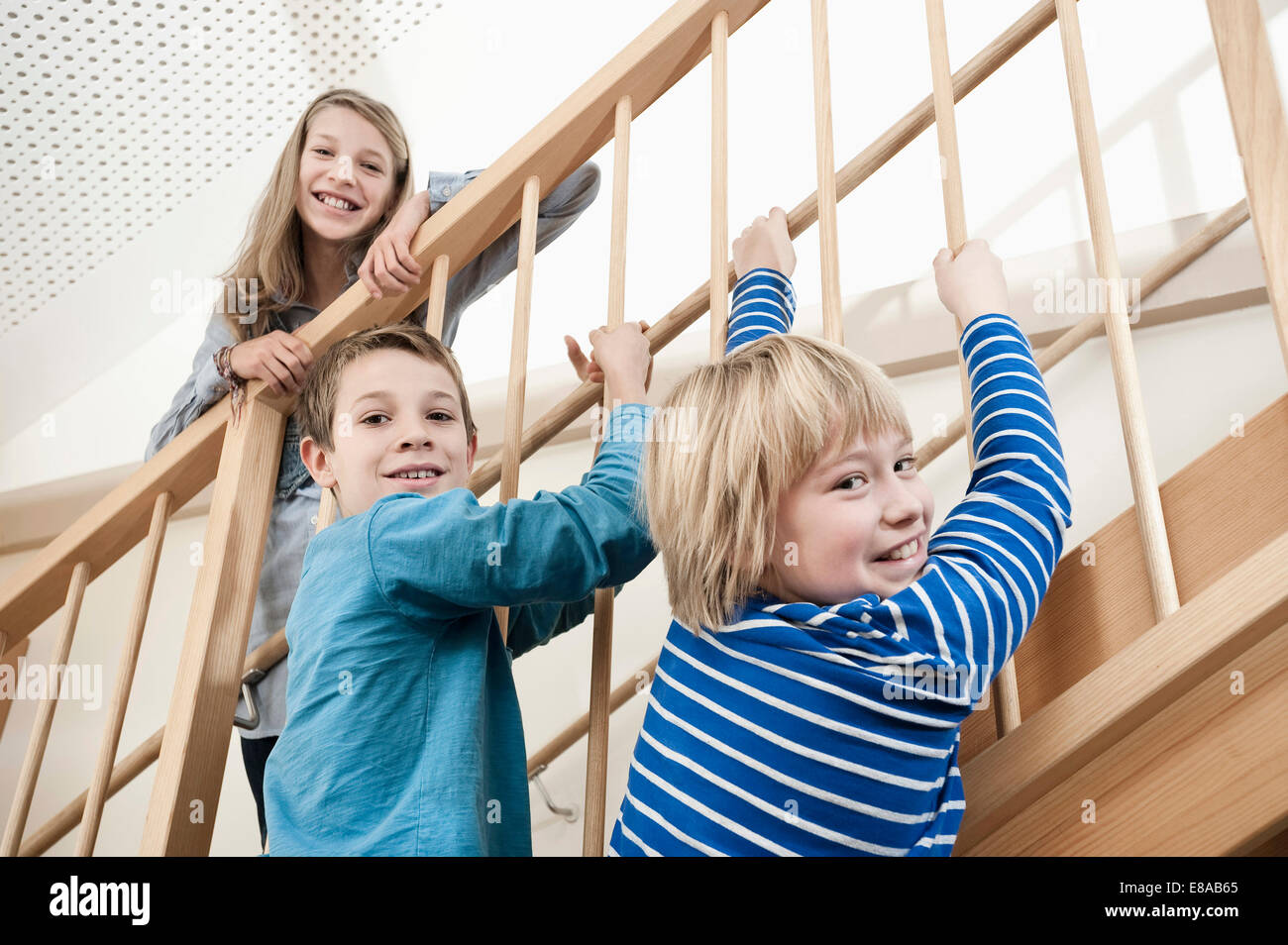 Three children at staircase Stock Photo - Alamy