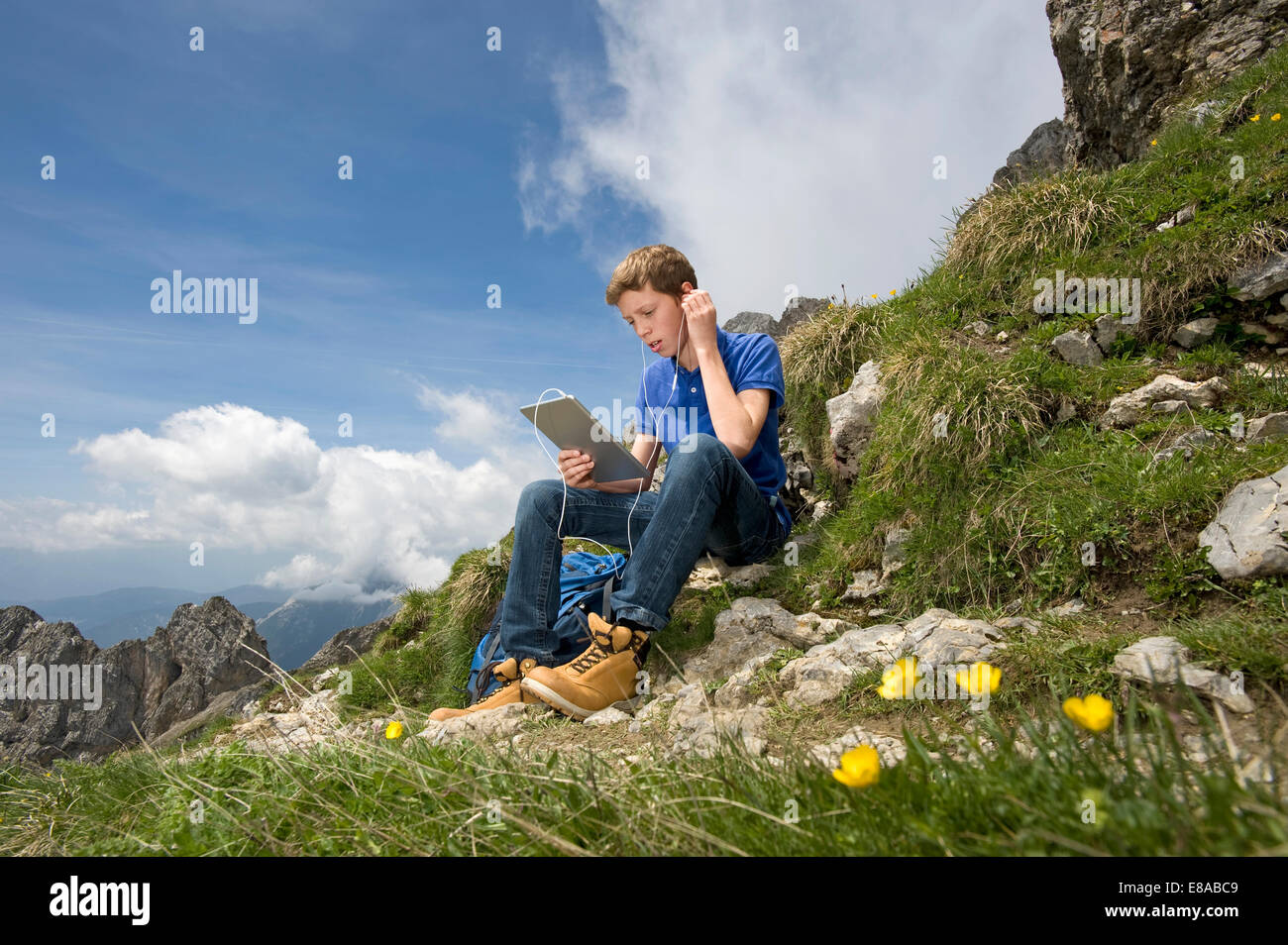Teenage boy using iPad in mountain landscape Stock Photo - Alamy