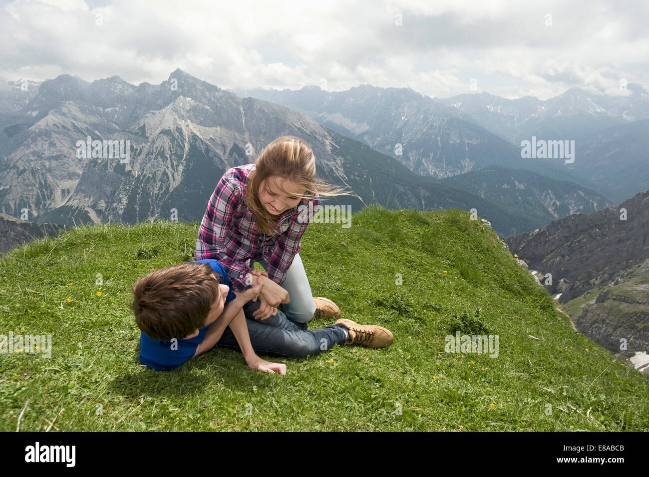 Young girl and boy playing wrestling on grass Alps Stock Photo - Alamy
