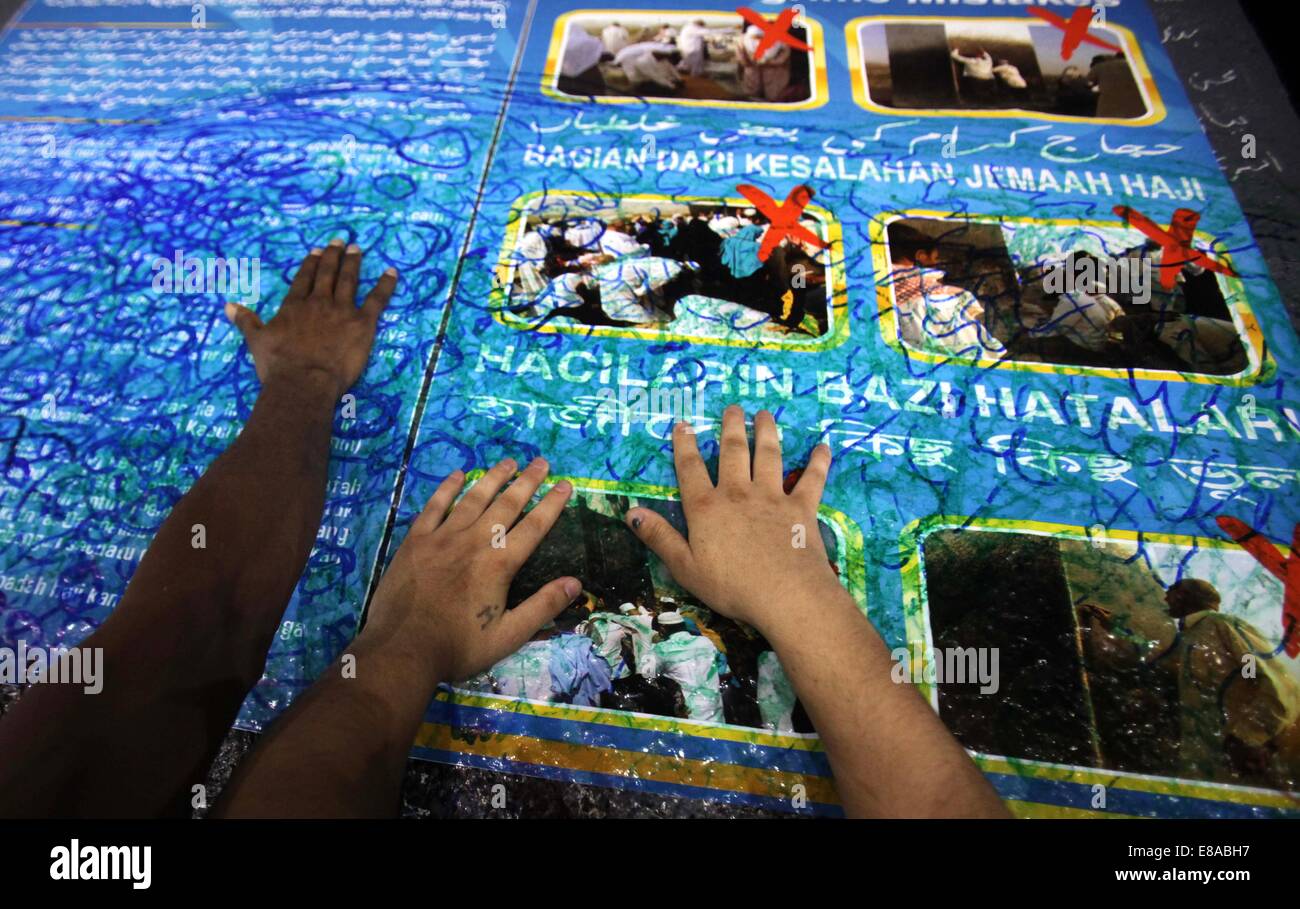 Mecca, Saudi Arabia. 3rd Oct, 2014. Muslim pilgrims touch a rock as ...