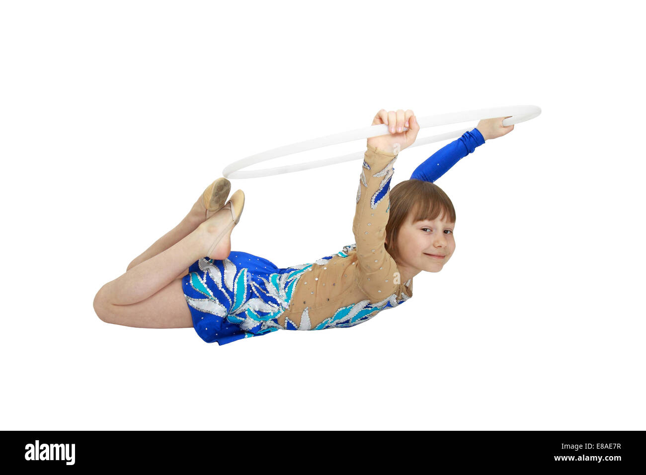 Girl lies in gymnastic exercise position holding gymnastic hoop over ...