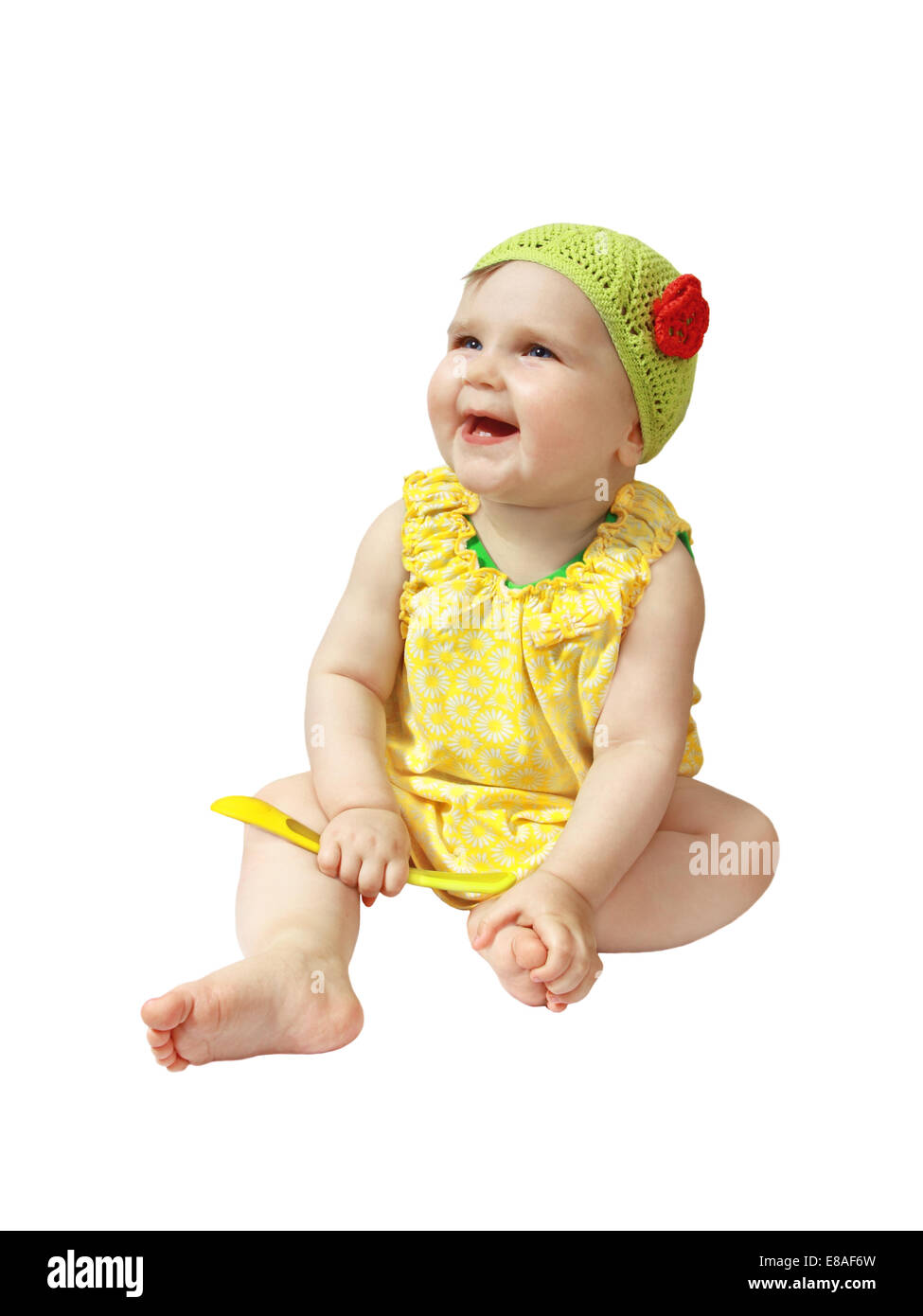 Infant laughs and hold spoon in his hand isolated on white background ...