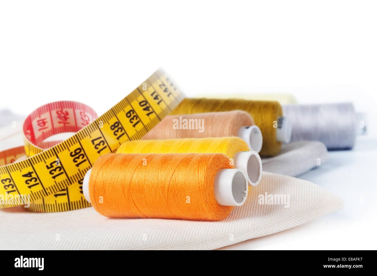 Orange spools of thread and measuring tape Stock Photo - Alamy