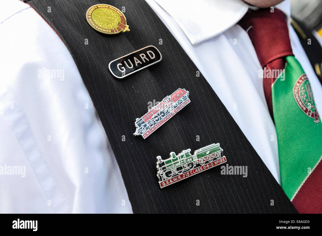 A guard at a steam train museum wears metal badges on his waistcoat ...