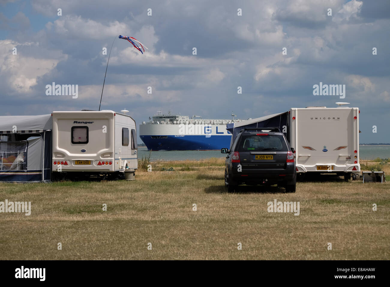 The car transporter Glovis spirit passes RV campers on the foreshore of ...