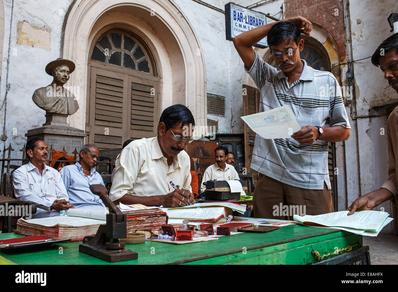 Notary signs documents outside one of court buildings in Kolkata, India ...