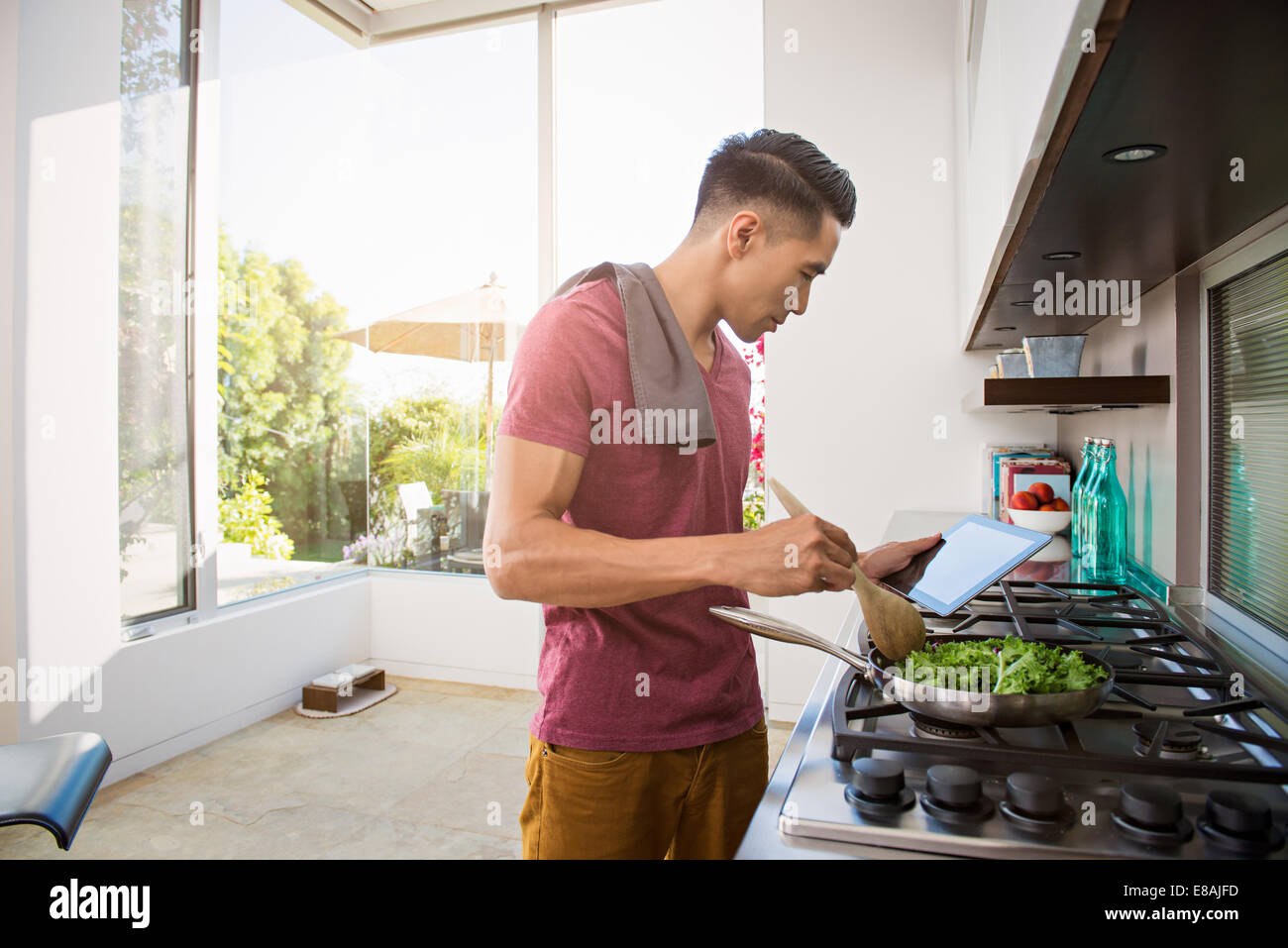 Young man following cooking instructions in kitchen Stock Photo - Alamy