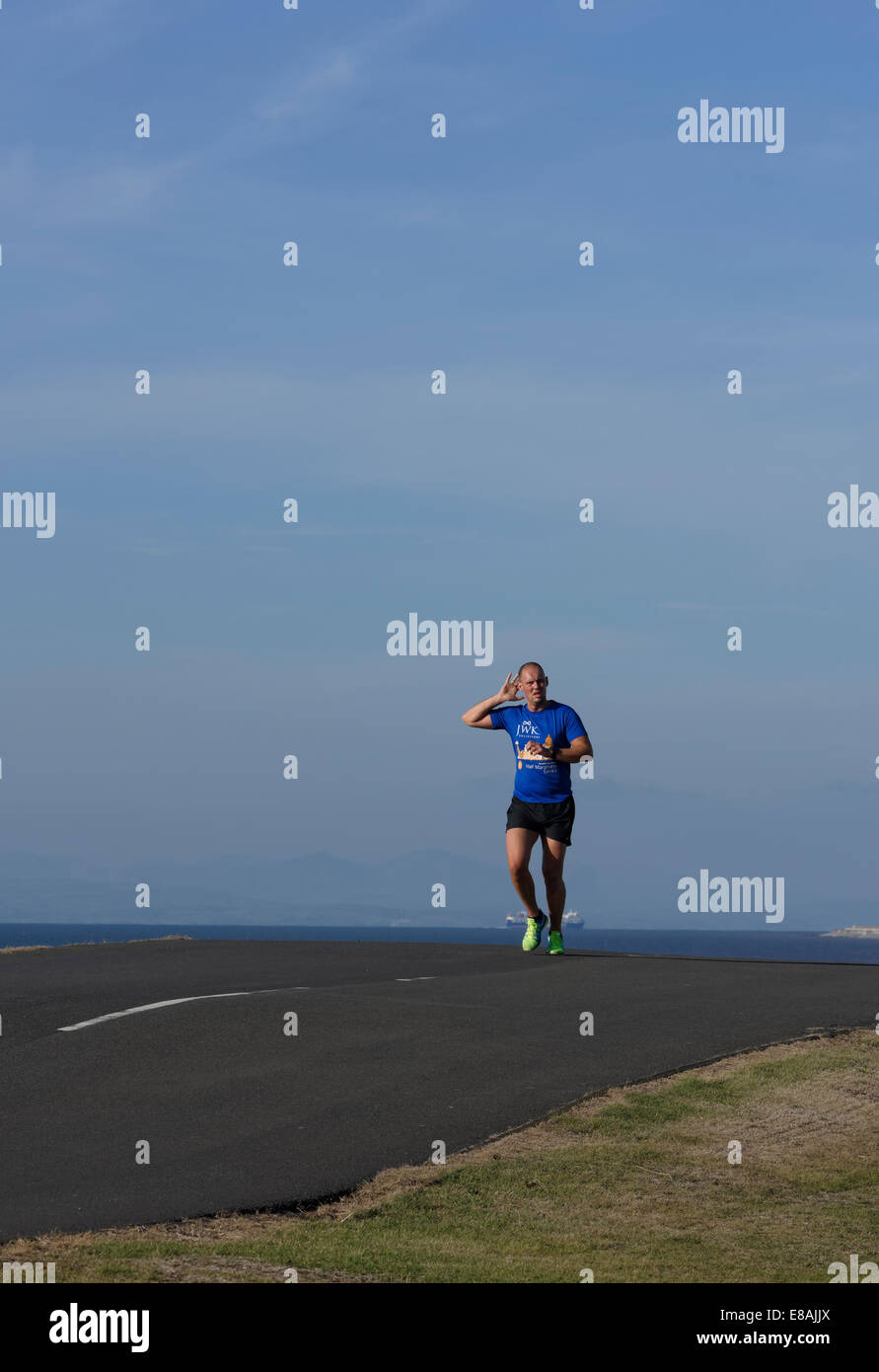 Man jogging alone along a coastal path in Blackpool, Lancashire, UK ...