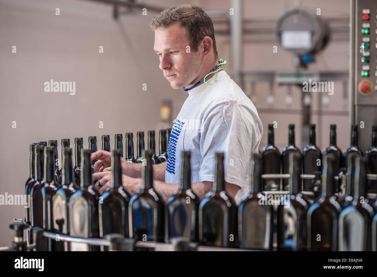 Young man working on production line in bottling plant Stock Photo - Alamy