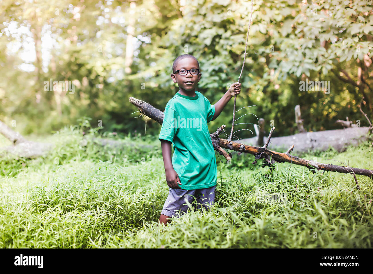 Portrait of boy touching fallen tree in forest eco camp Stock Photo - Alamy