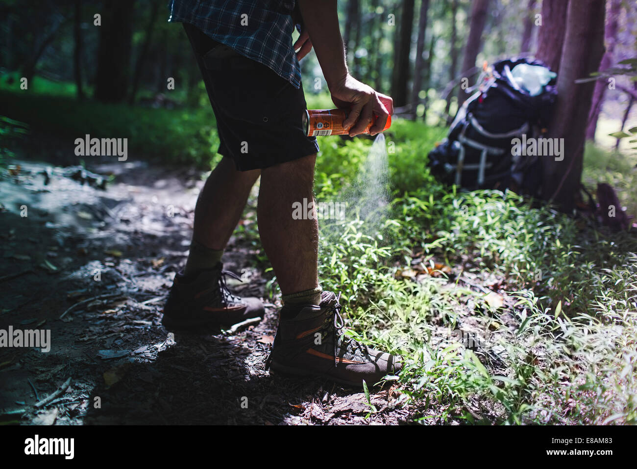Hiker spraying bug spray with DEET Stock Photo - Alamy