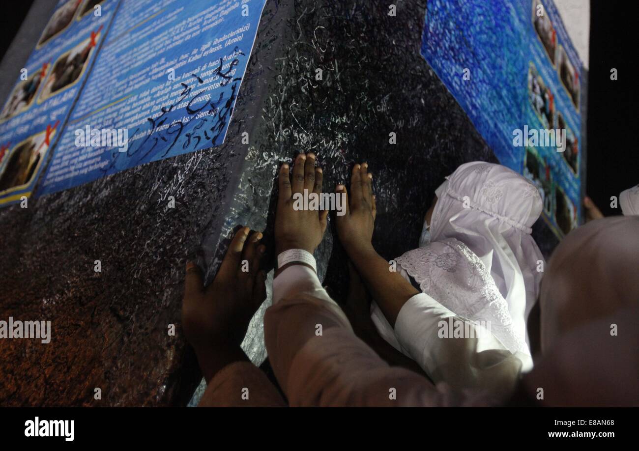 Mecca, Saudi Arabia. 3rd Oct, 2014. Muslim pilgrims touch a rock as ...