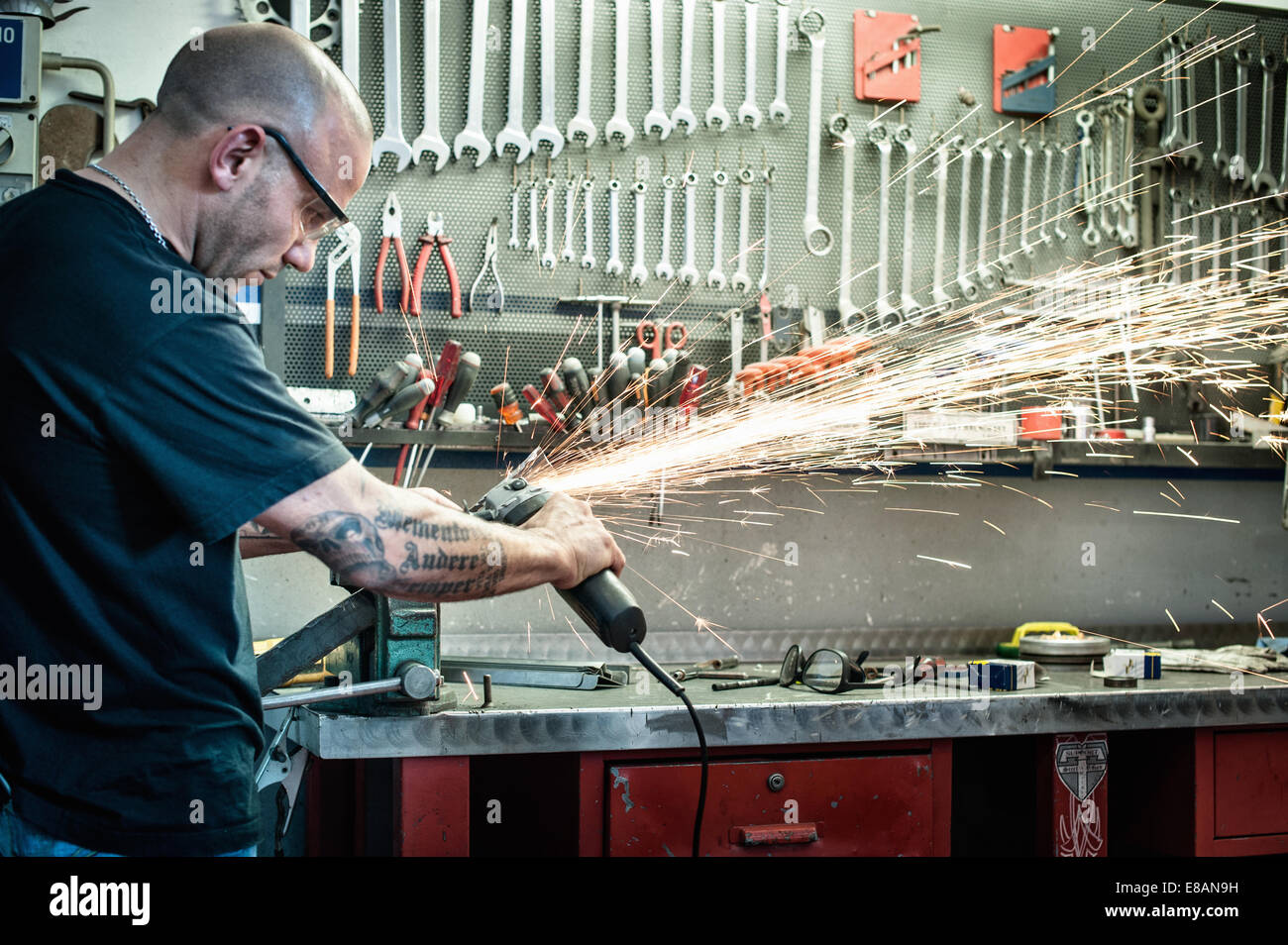 Male mechanic grinding metal in workshop Stock Photo - Alamy