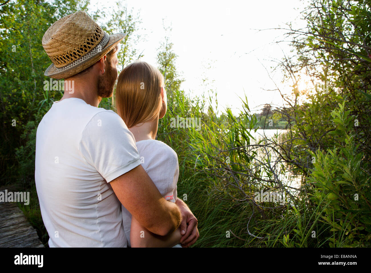 Romantic mid adult couple watching lakeside sunset Stock Photo - Alamy