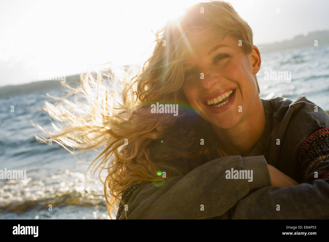 Woman all wrapped up on windy beach Stock Photo - Alamy