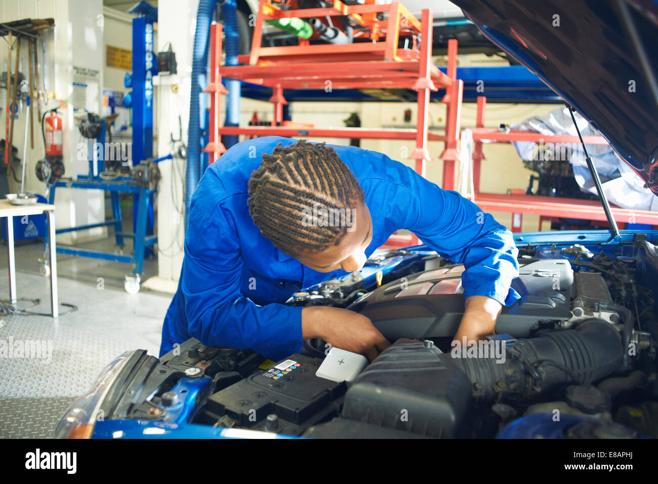 Male college student looking at car engine in garage workshop Stock ...