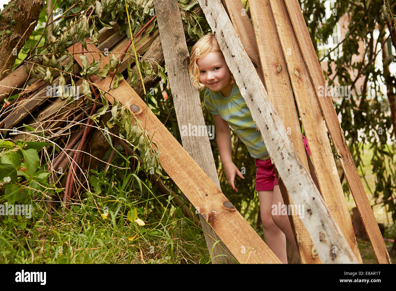 Portrait of girl hiding in garden den Stock Photo - Alamy