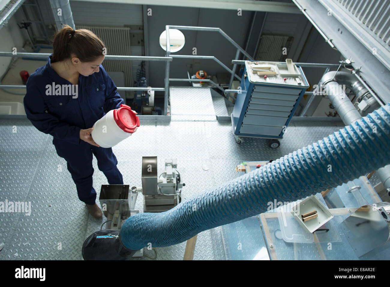 High angle view of factory worker reading instructions on plastic ...
