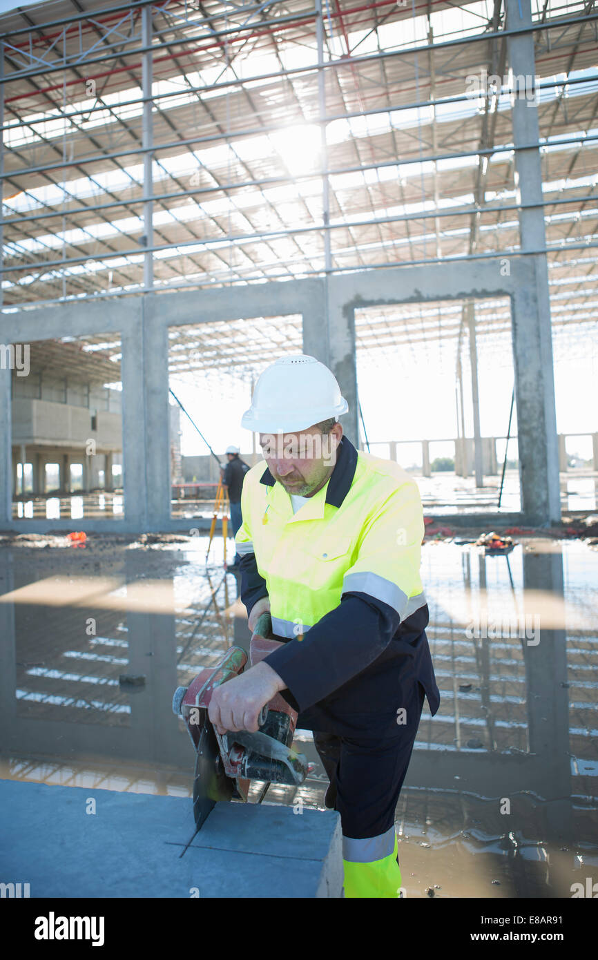 Builder using rotating saw on construction site Stock Photo - Alamy