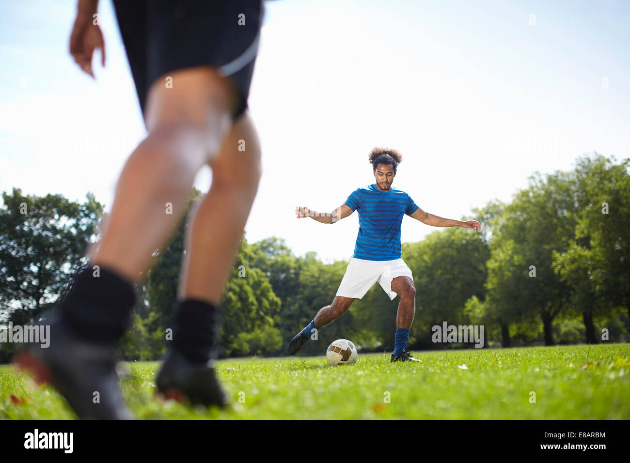 Young couple playing football together in park Stock Photo - Alamy