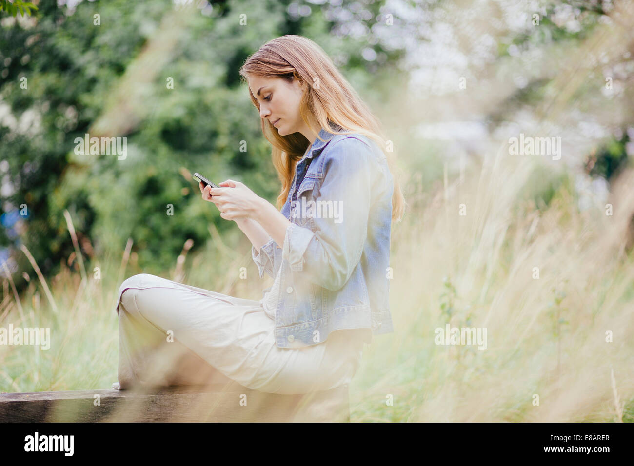 Young woman texts on smartphone hi-res stock photography and images - Alamy