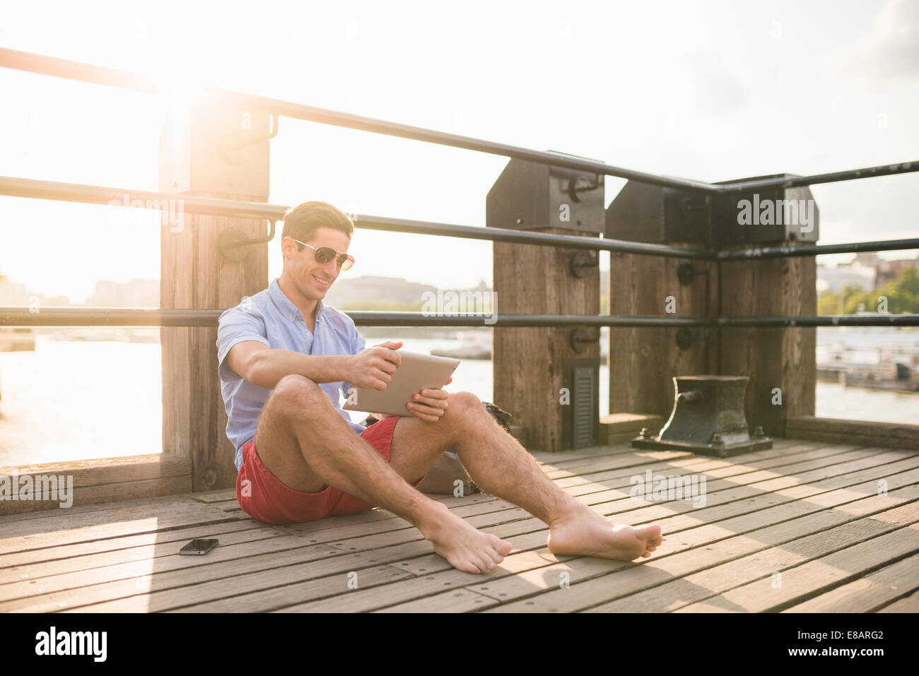 Man sitting on pier hi-res stock photography and images - Alamy