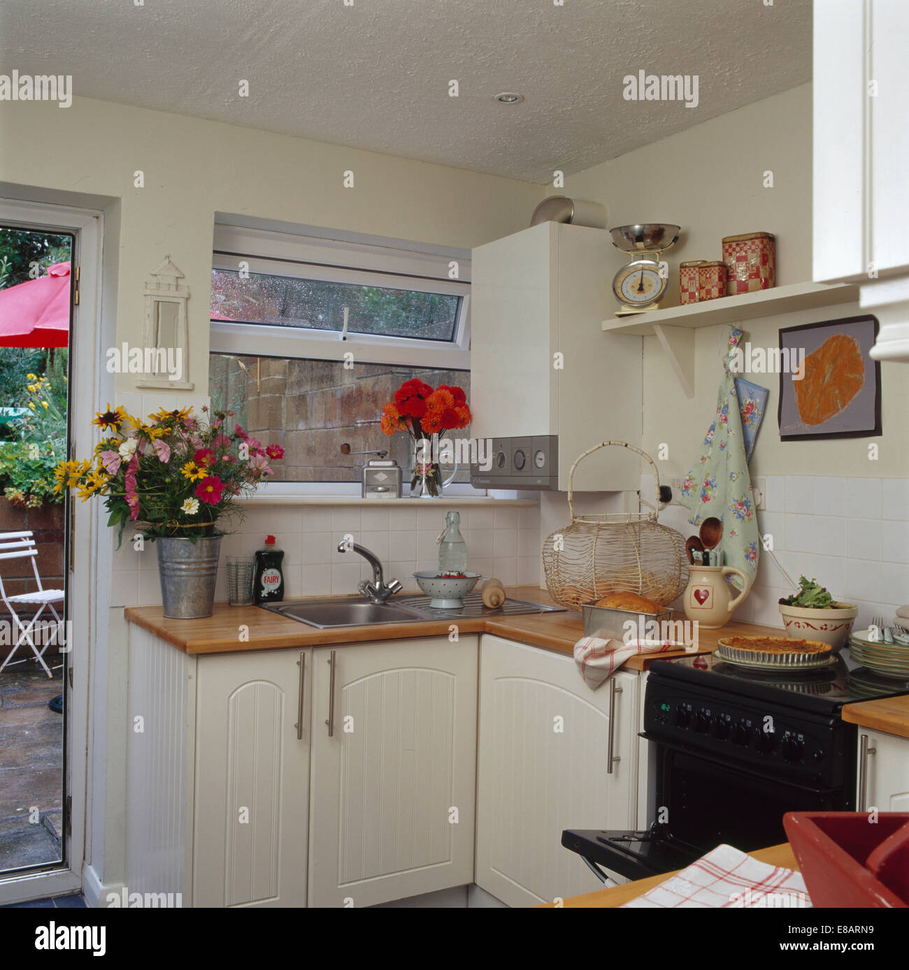 Central-heating boiler beside window in small cream cottage kitchen ...