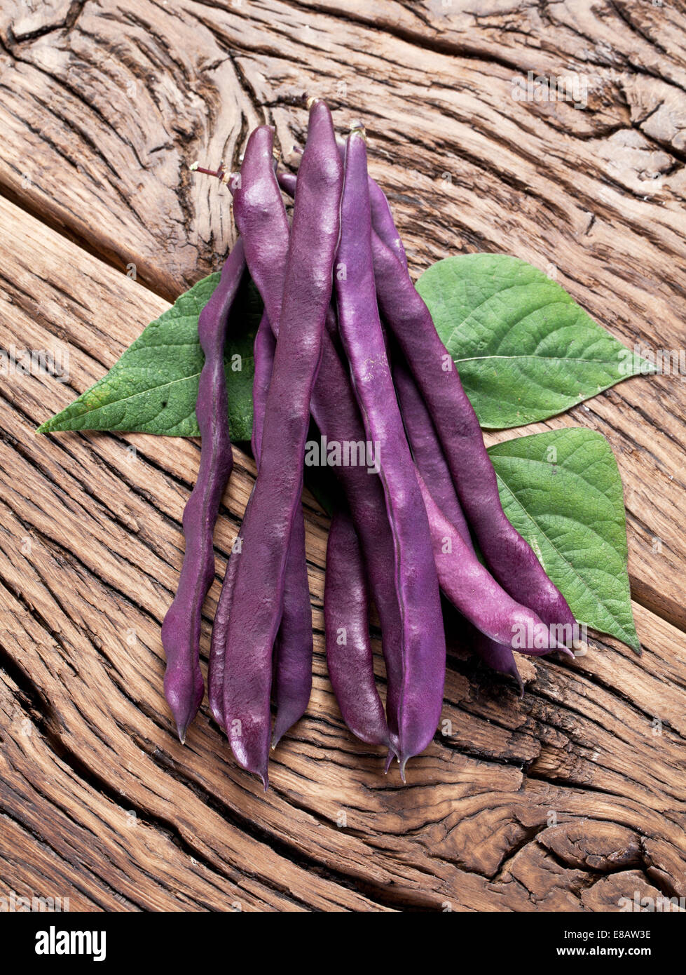 Violet beans on the old wooden table Stock Photo - Alamy