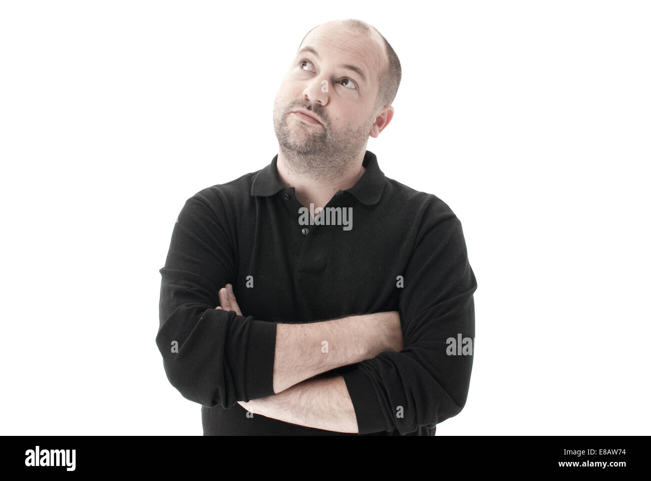 mid shot of a man with folded arms looking up and thinking shot against ...