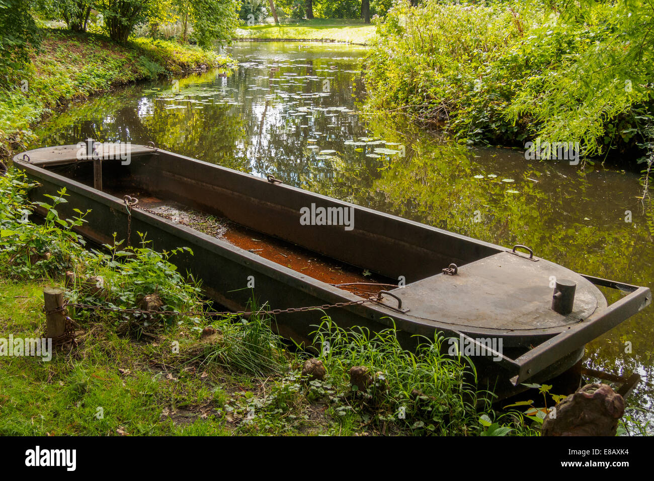 Old rusty boat by riverbank in park Stock Photo - Alamy