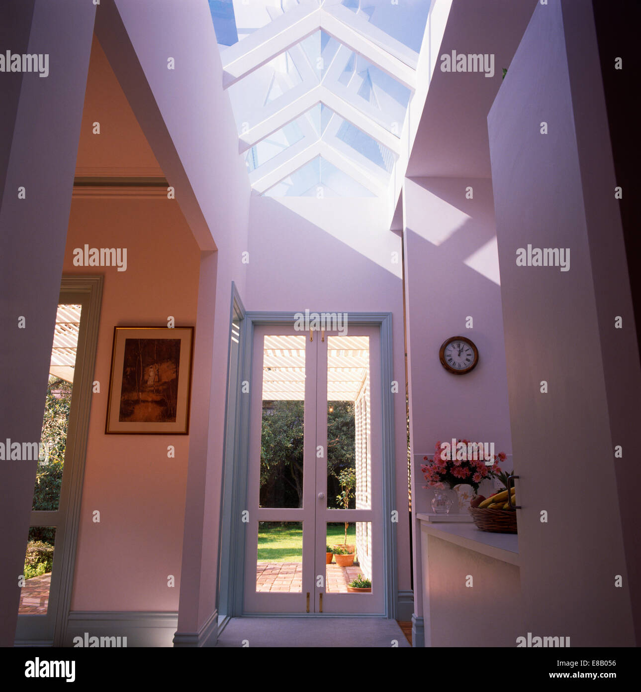 Glass apex roof in modern white hall with glass door painted in pastel ...