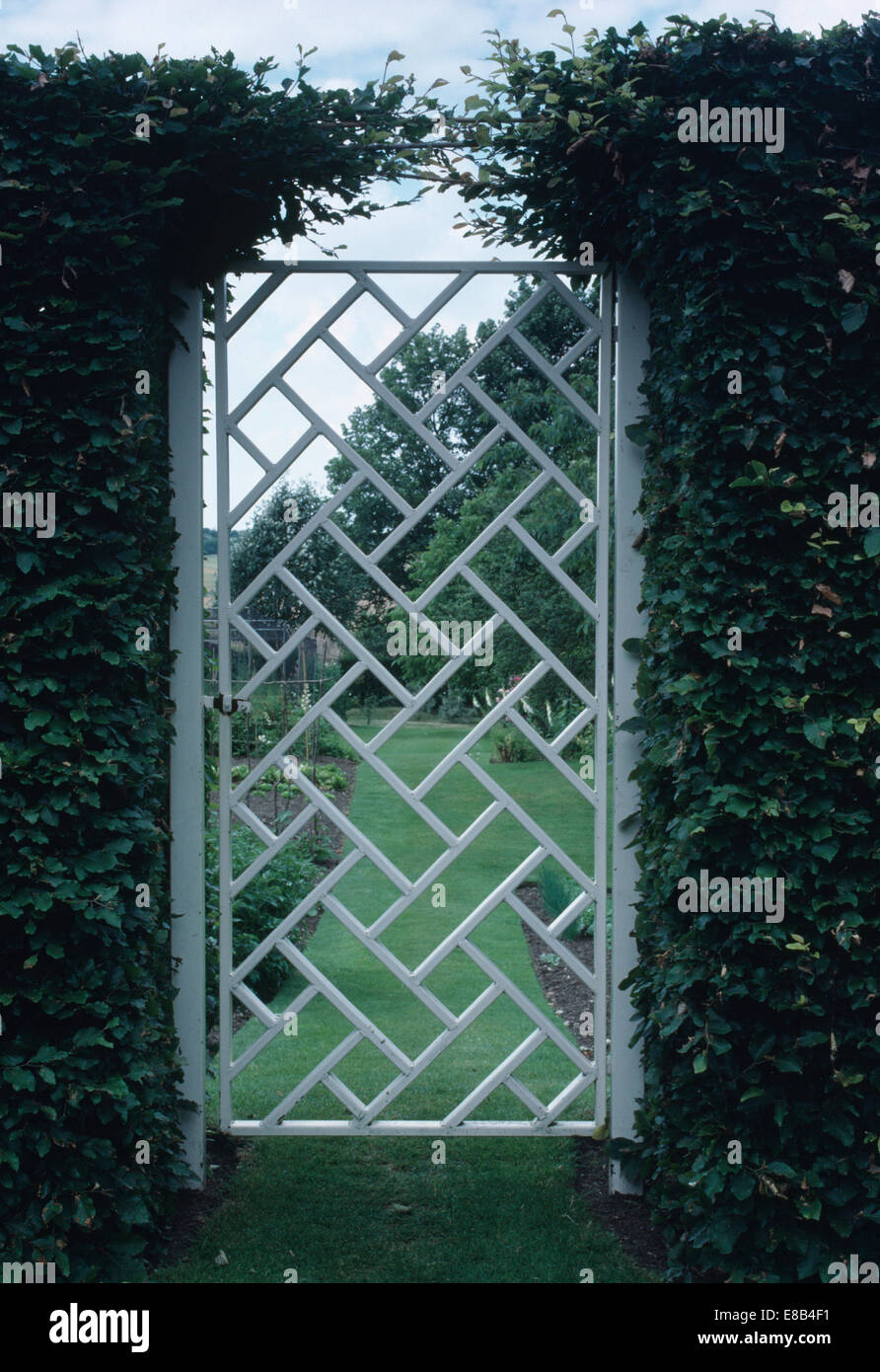 White herringbone pattern gate with view of country garden Stock Photo ...