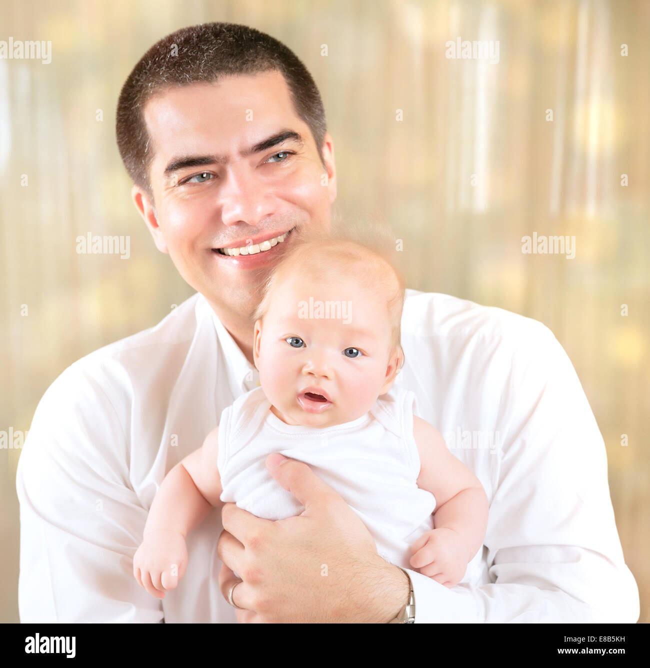 Happy family at home, portrait of cheerful smiling father holding on hands his cute little ...