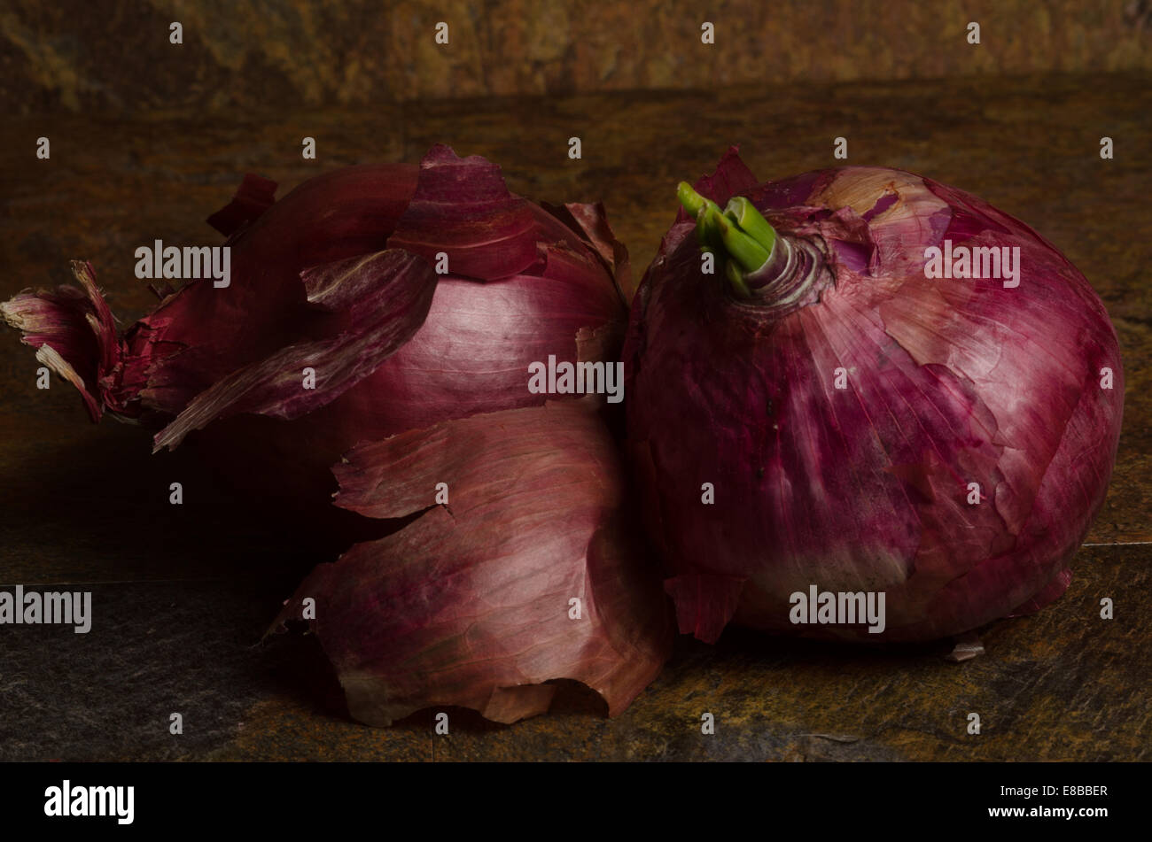 two red onions over a stone textured table Stock Photo - Alamy