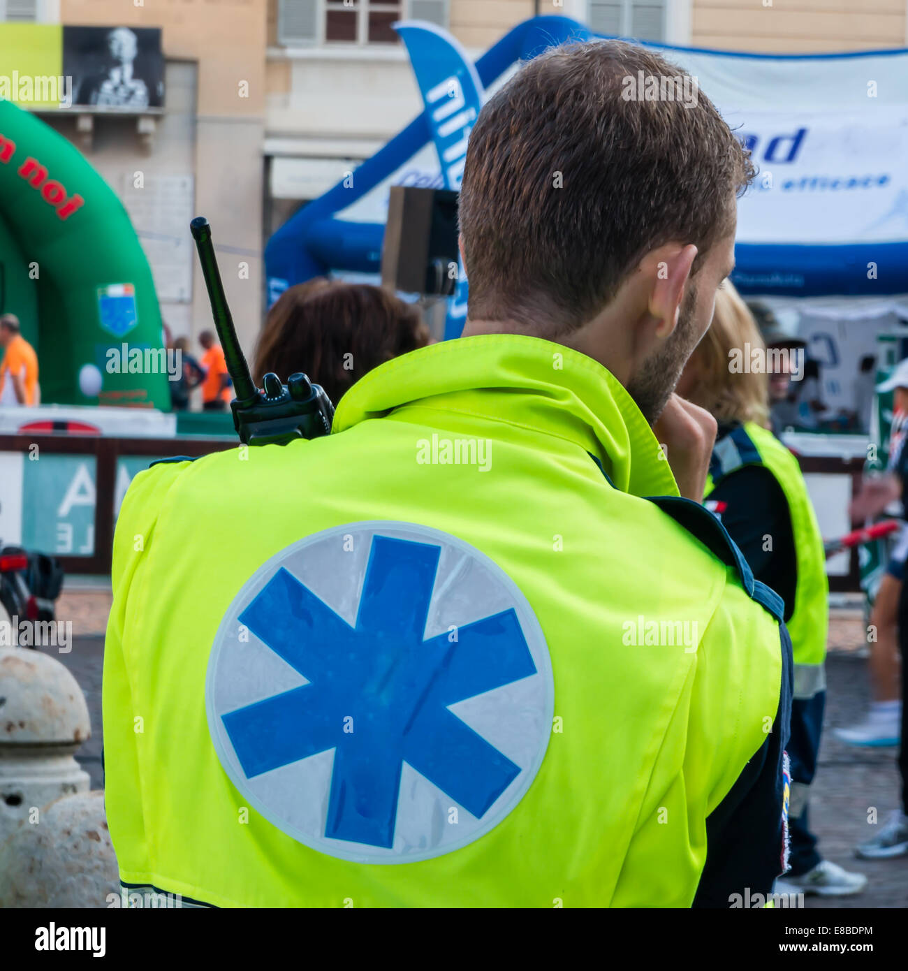 Paramedic with radio equipment wait for call; blue and yellow dressed ...