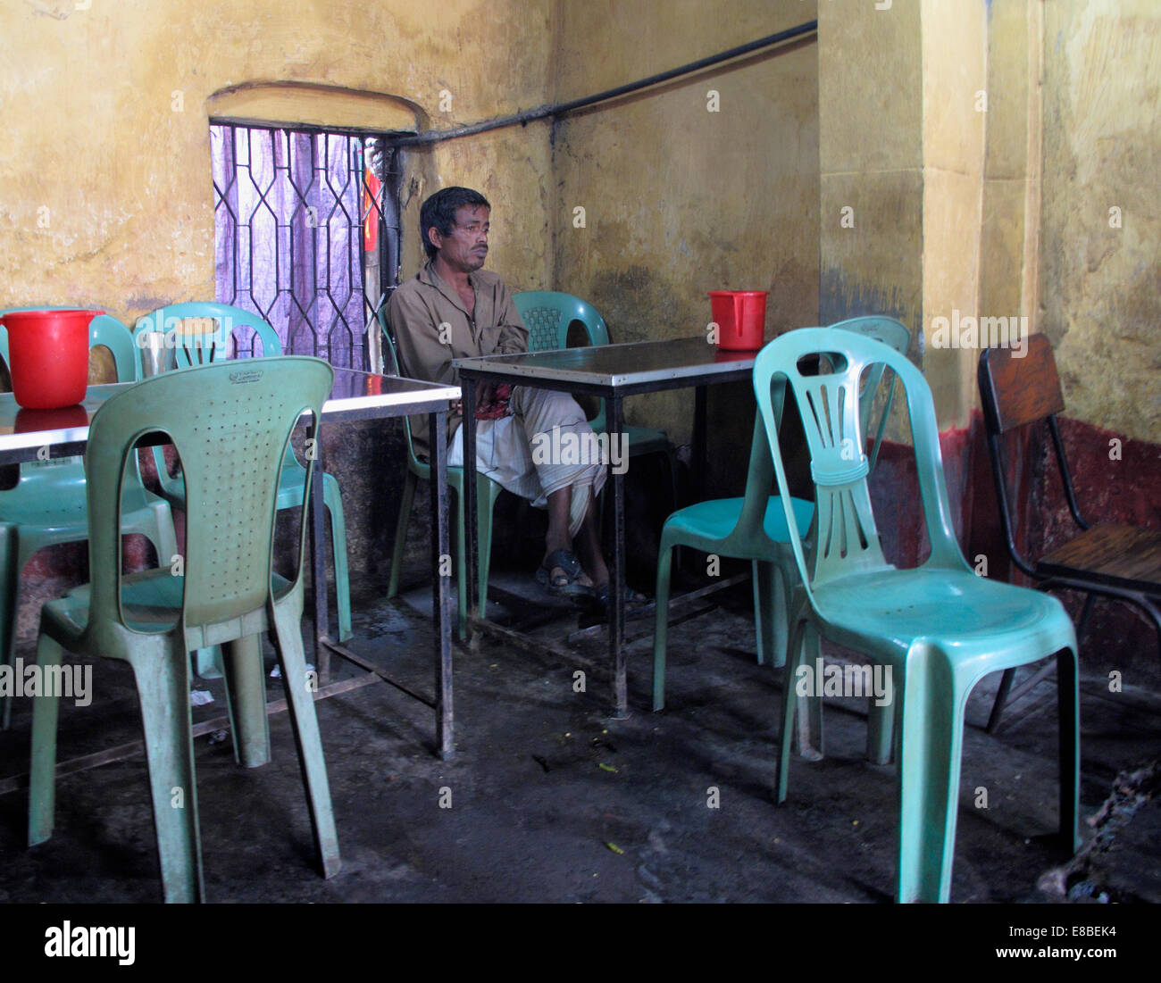 Tired man sitting in local restaurant, waiting for a mill,run down ...