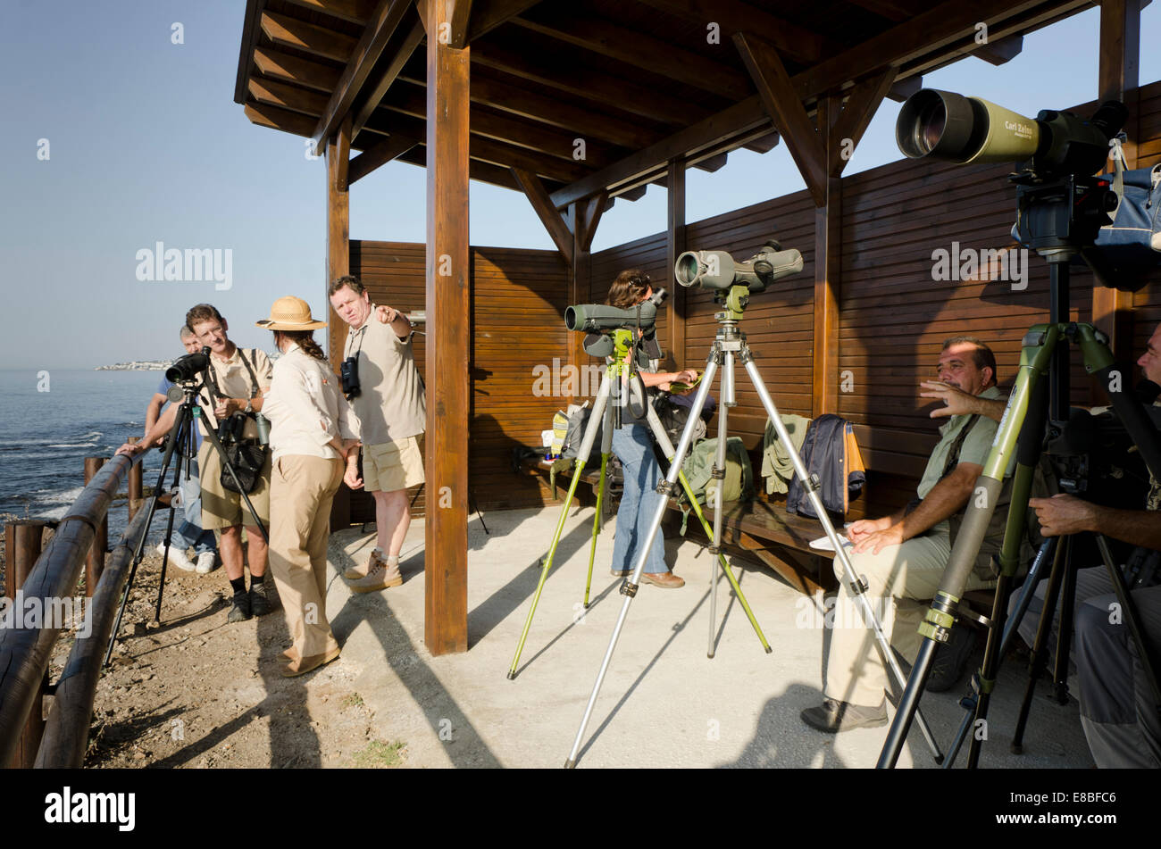 Group of birdwatchers with telescopes scanning the mediterranean sea ...